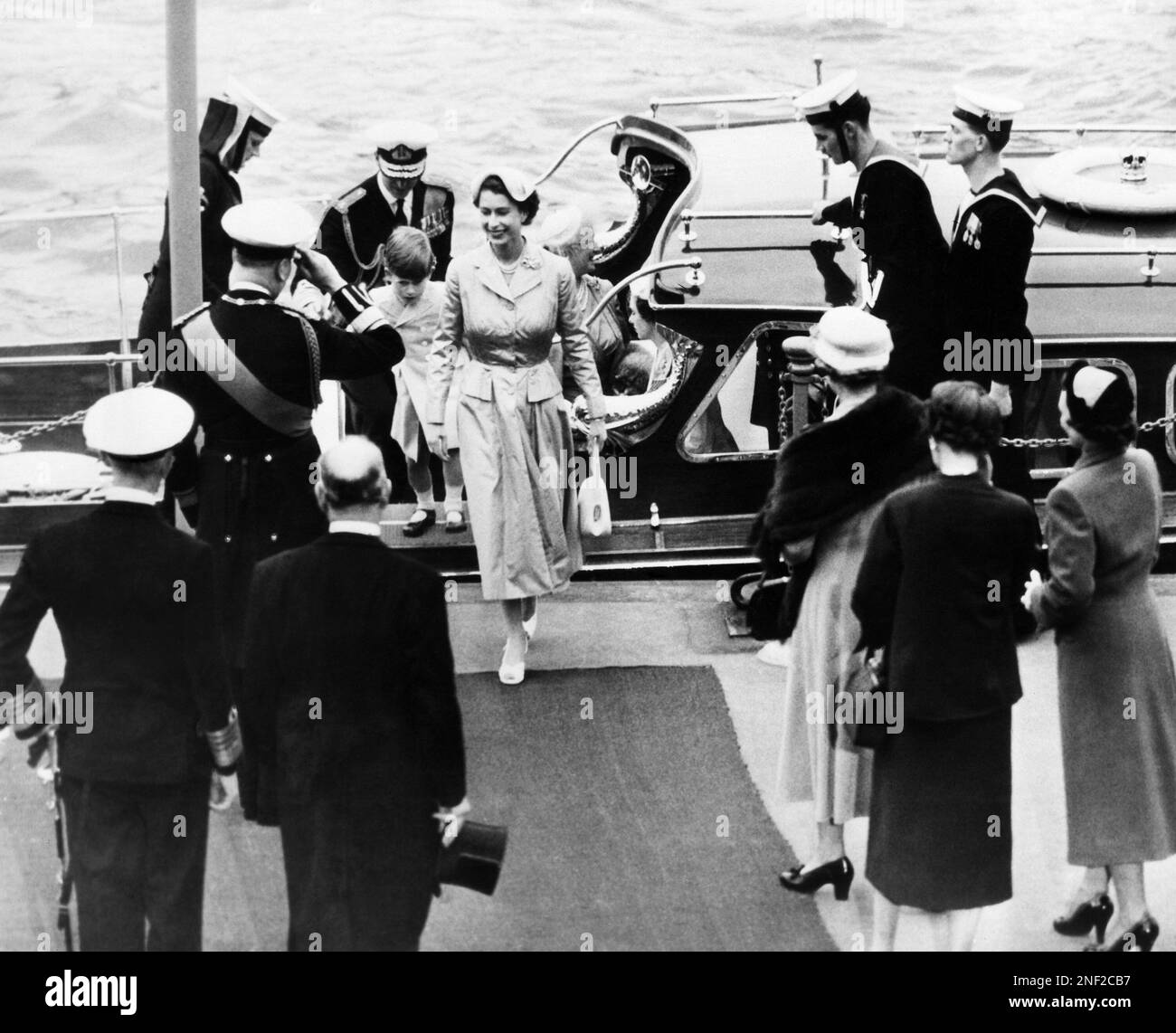 Queen Elizabeth II is followed by Prince Charles and her husband, the ...