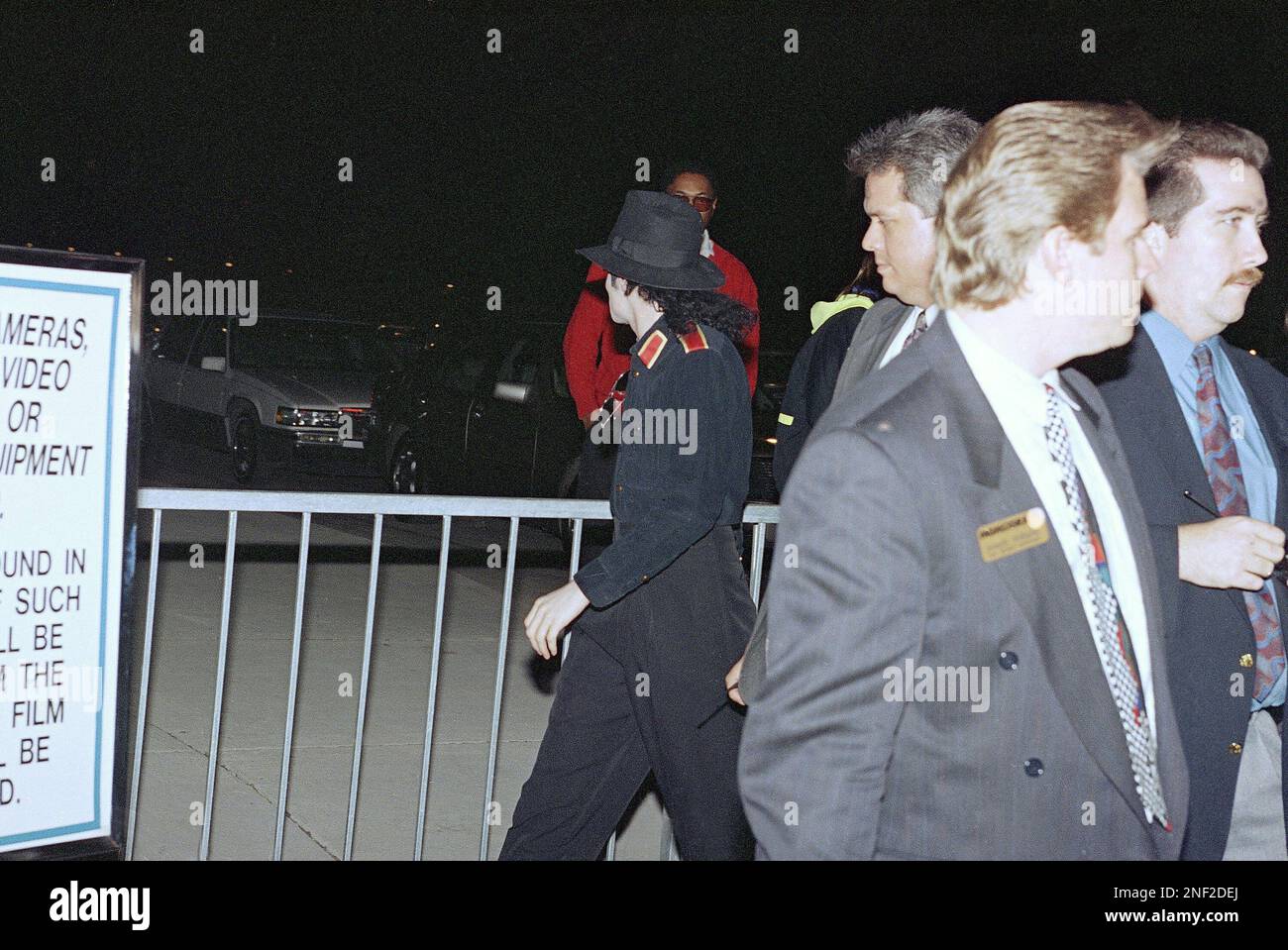 Entertainer Michael Jackson looks away as he walks swiftly past, behind ...