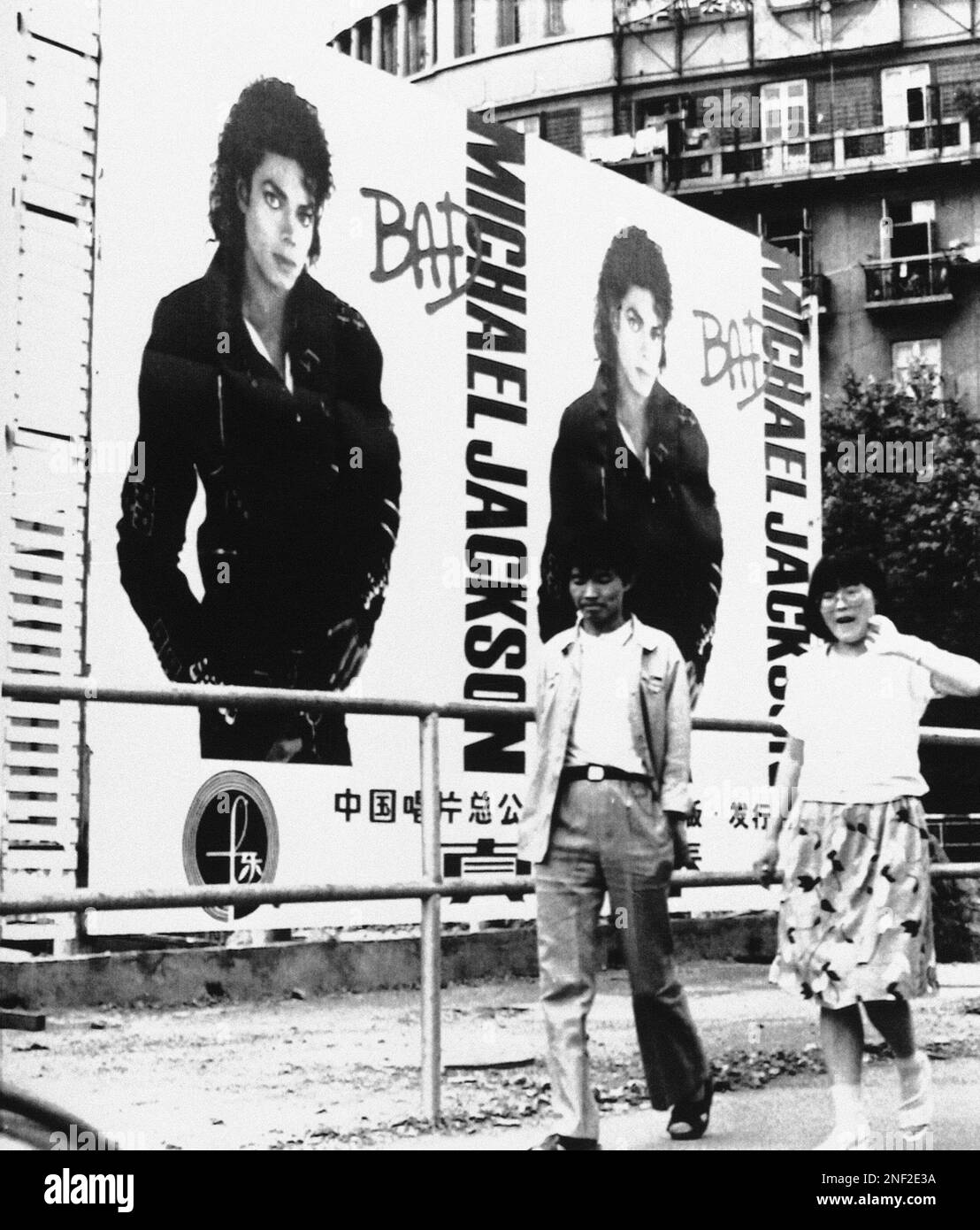 Two residents walk past a billboard advertising singer Michael Jackson ...