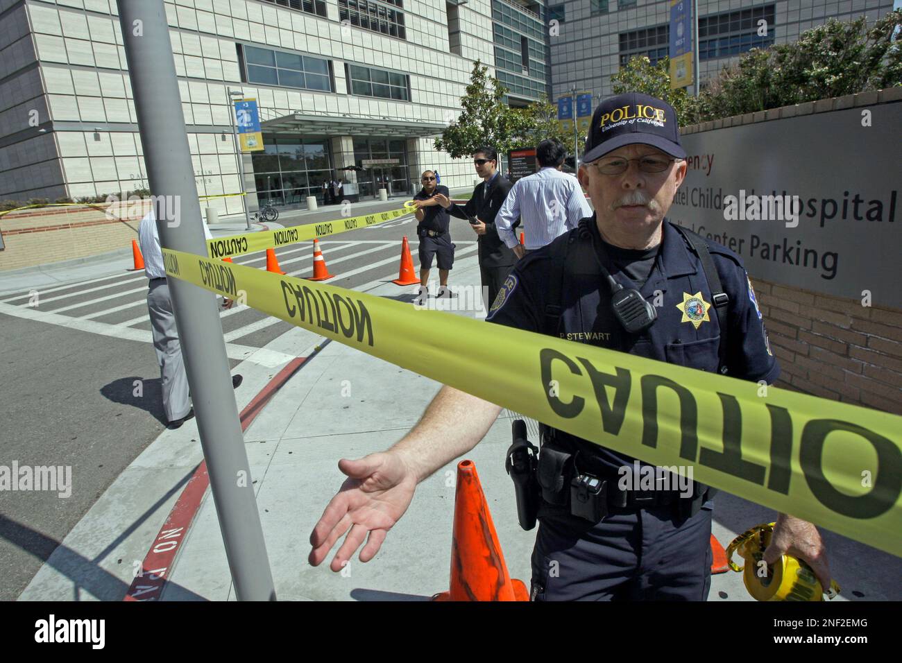 A UCLA police officer clears a sidewalk outside the emergency room at ...