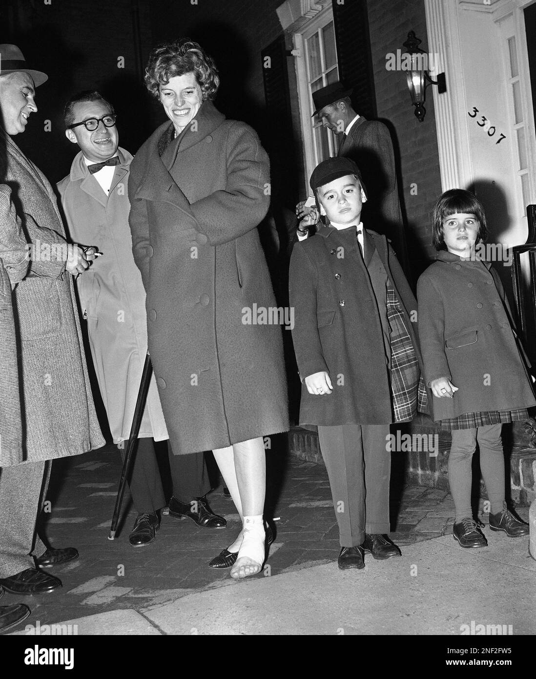Mrs. Eunice Shriver uses a cane to support her injured left ankle as ...