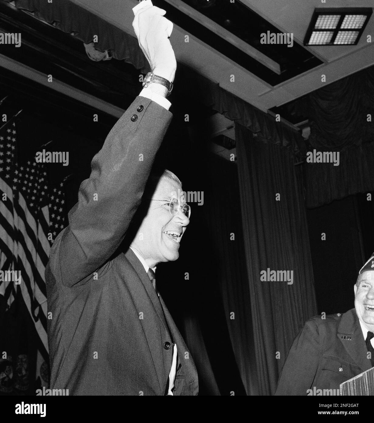 Secretary of Defense Robert McNamara waves a souvenir package of ...