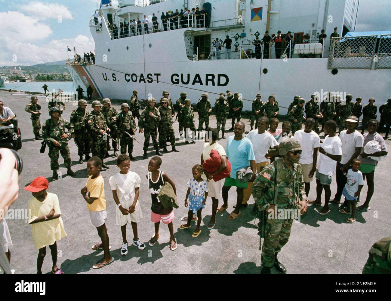 Repatriated Haitian Boat People Pass By A U S Army Guard Shortly After