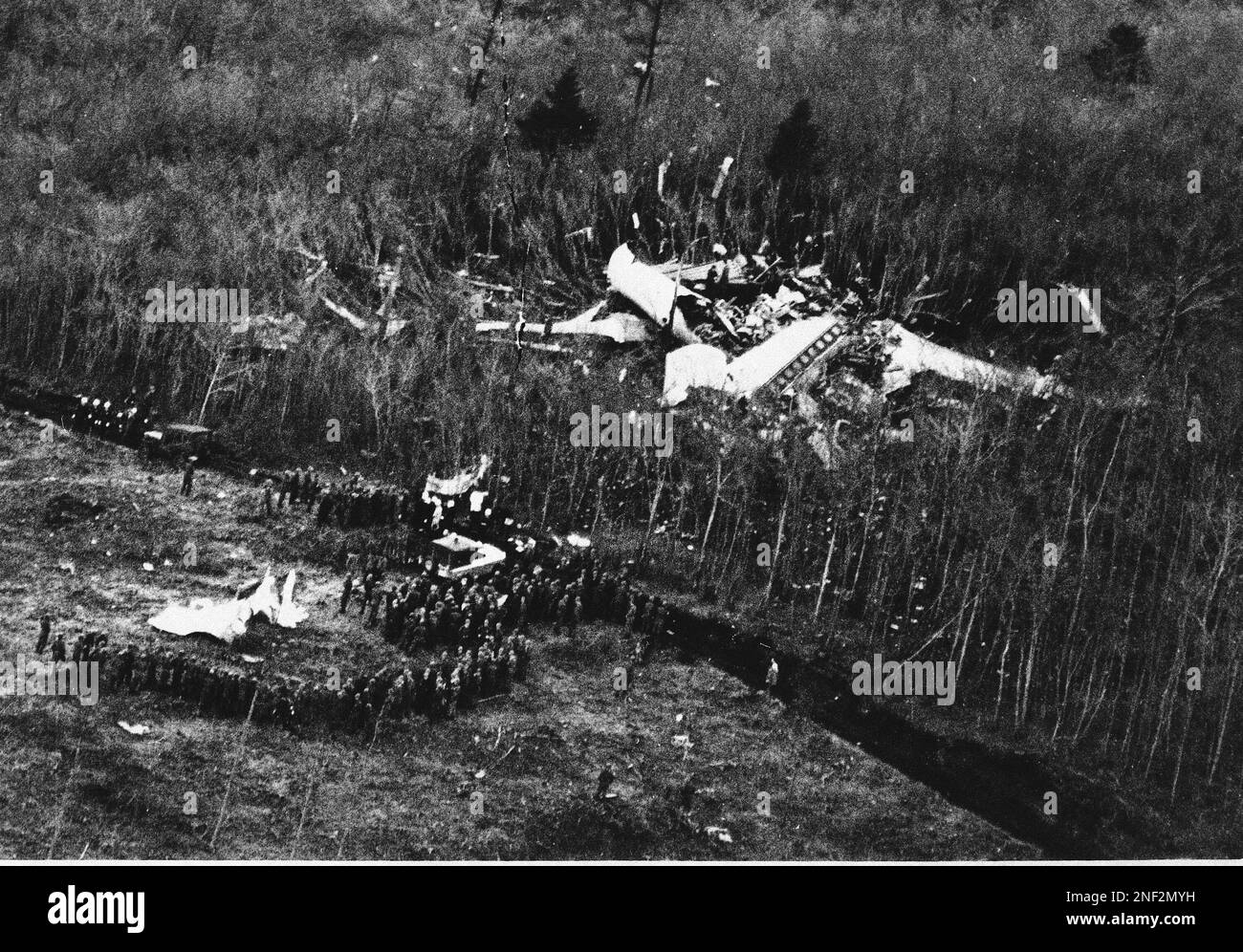 Rescue workers gather around bits of wreckage, lower left, at scene of ...
