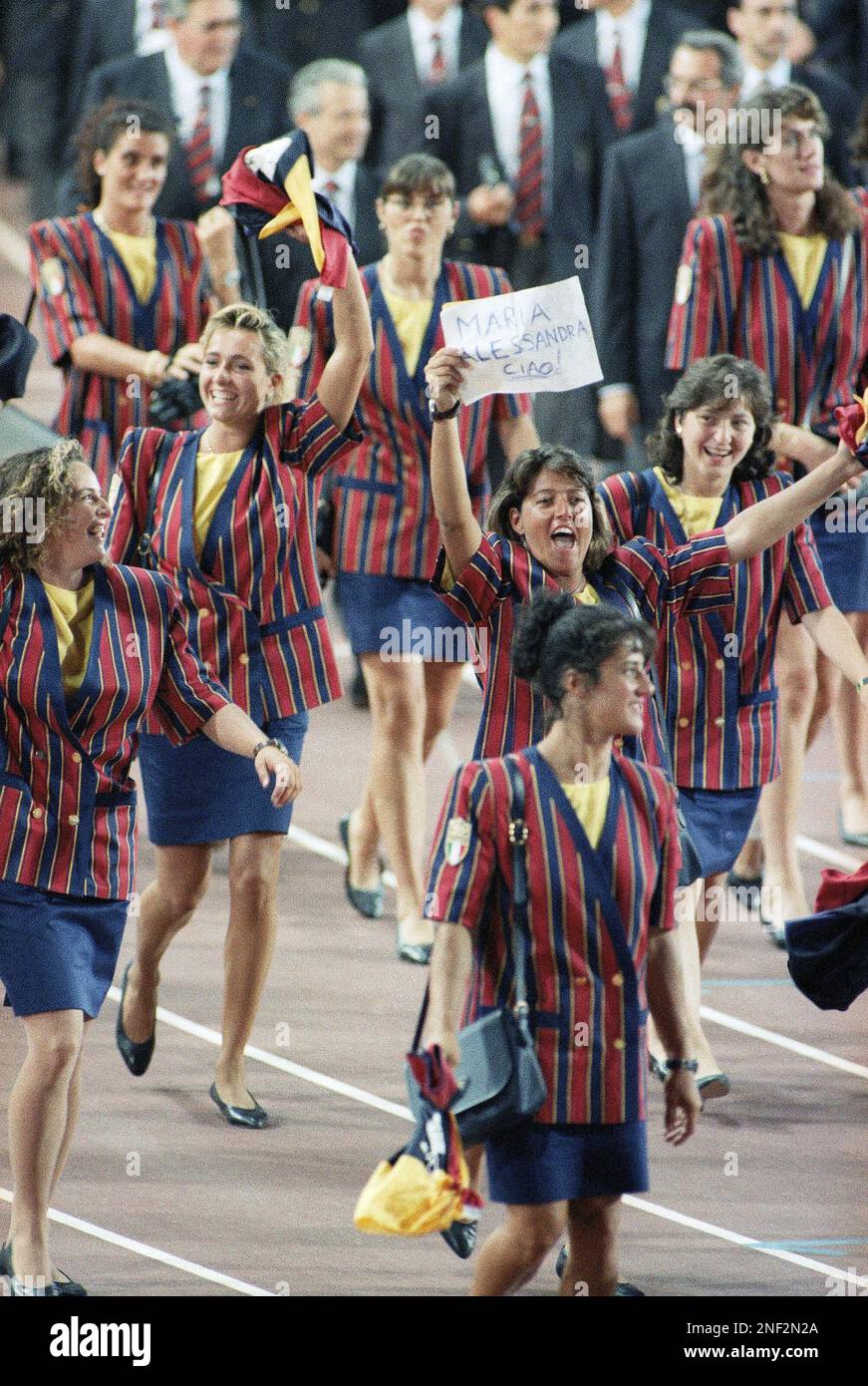 An athlete from Italy's Olympic team holds up a sign while she marches ...