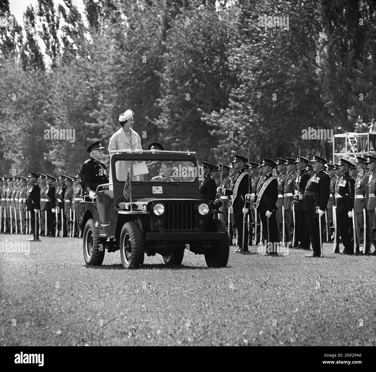 Queen Elizabeth II stands in an army vehicle in Quebec City's Plains of ...