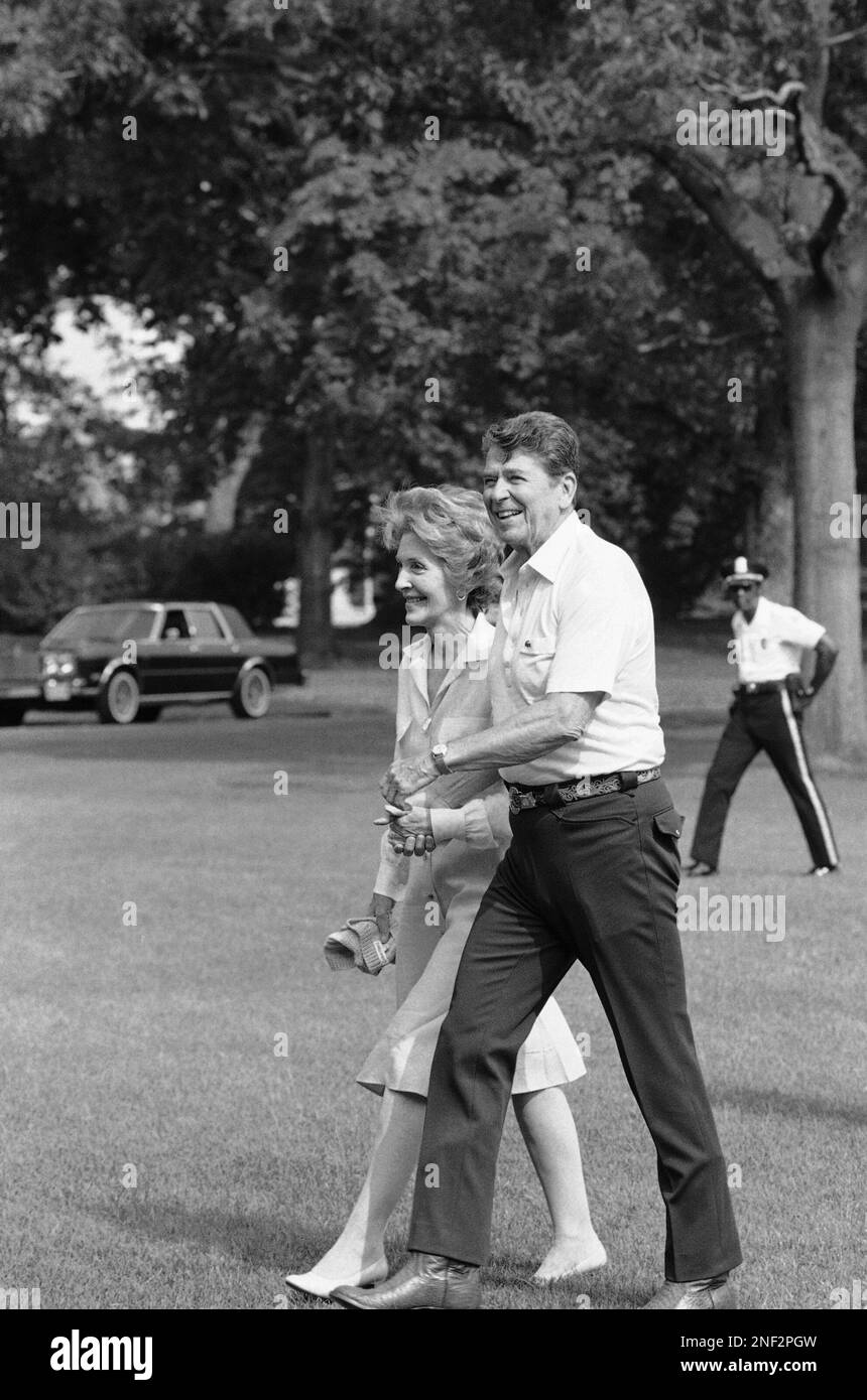 A smiling President Ronald Reagan and first lady Nancy Reagan hold ...