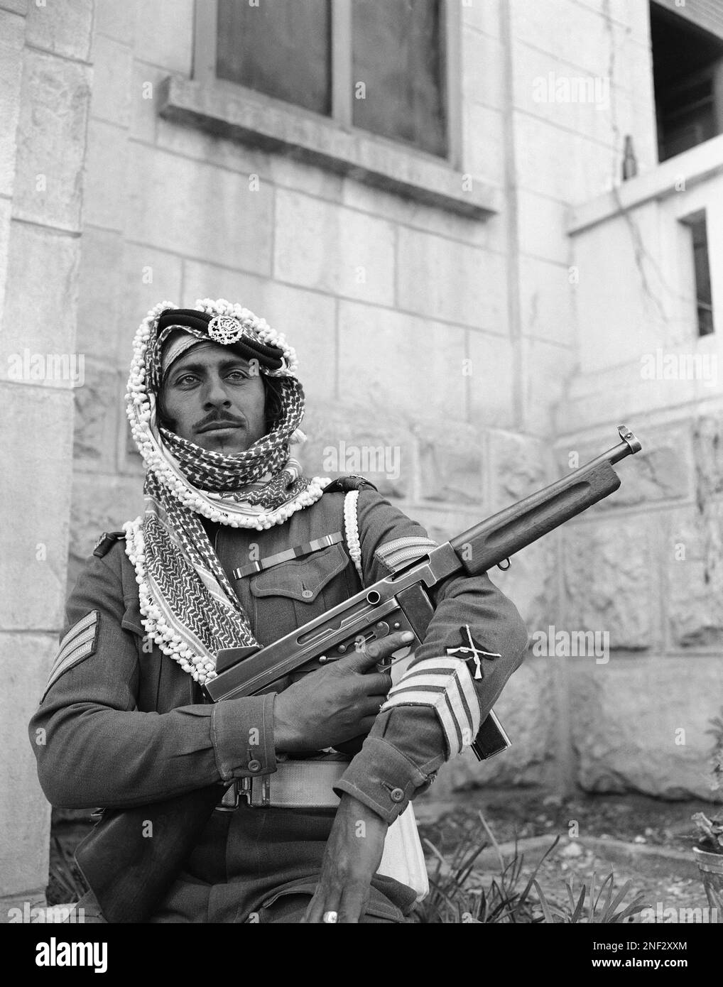 An Arab legion soldier fingers a machine gun as he stands guard in ...