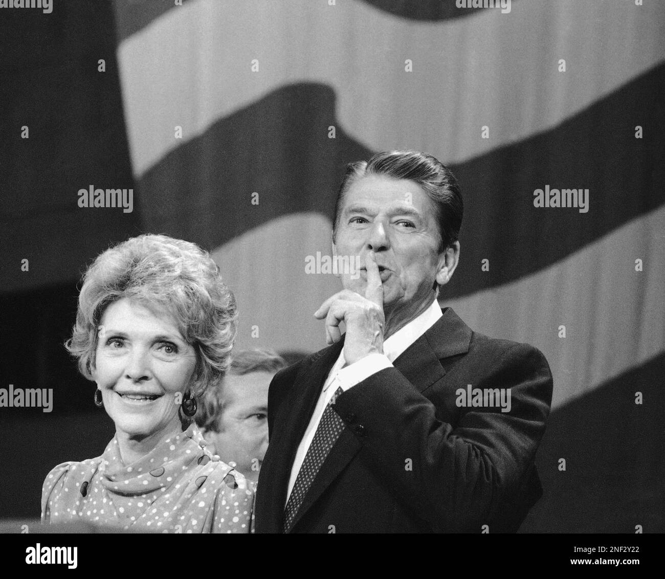 With first lady Nancy Reagan at his side, President Ronald Reagan tries ...