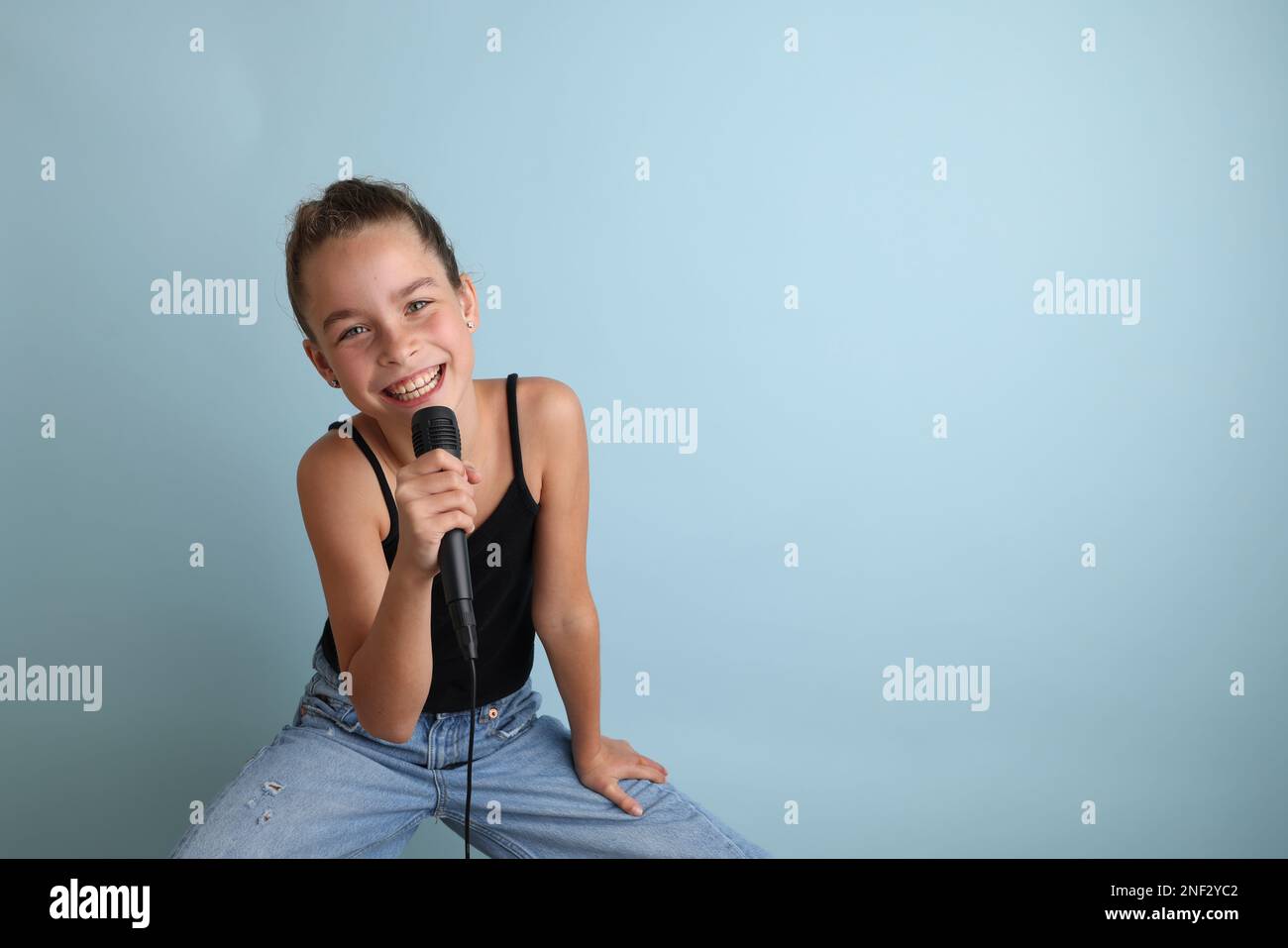 Portrait of a cute teenage girl singing, using microphone Stock Photo ...