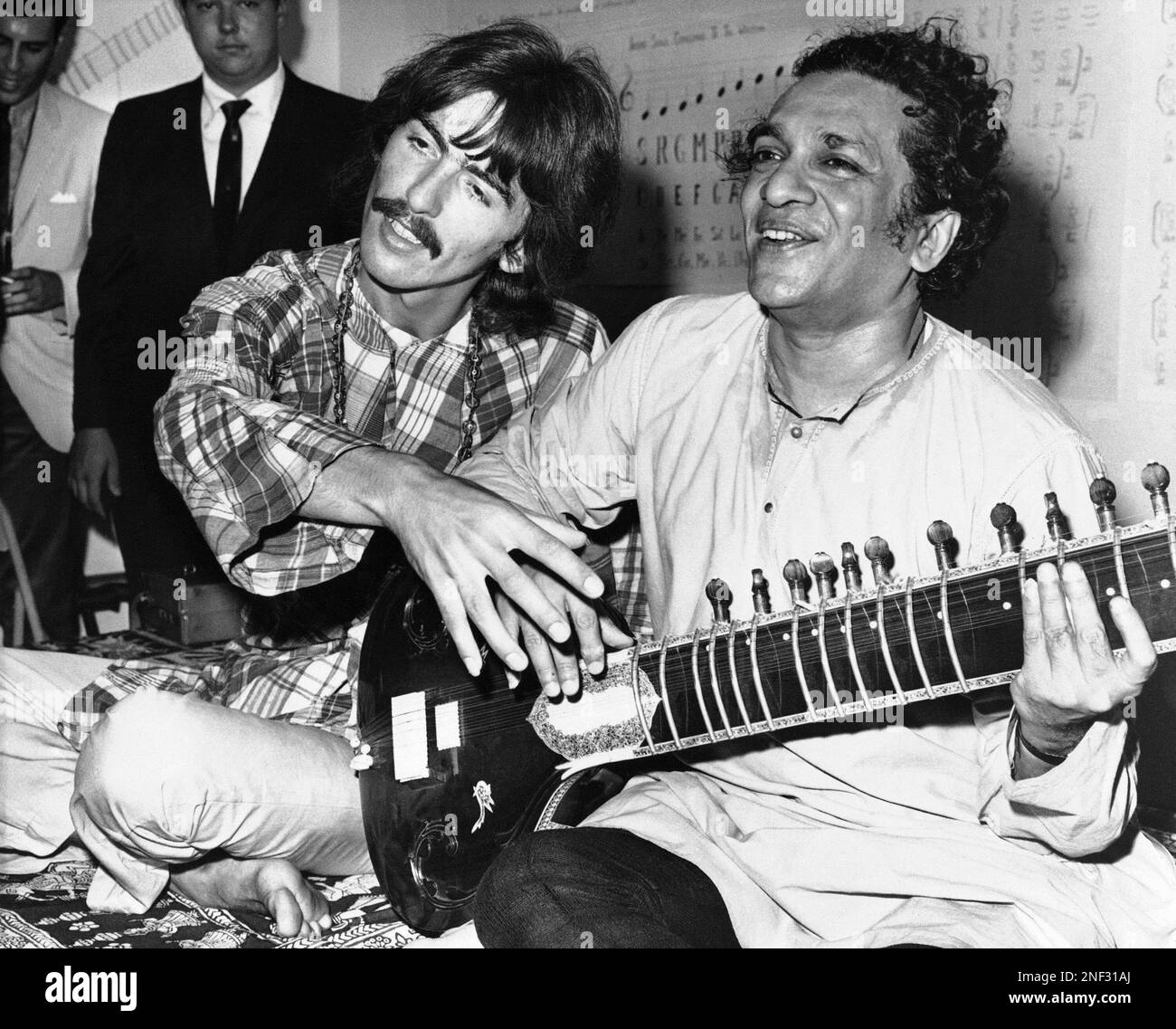 George Harrison of the Beatles sits cross-legged with his musical ...