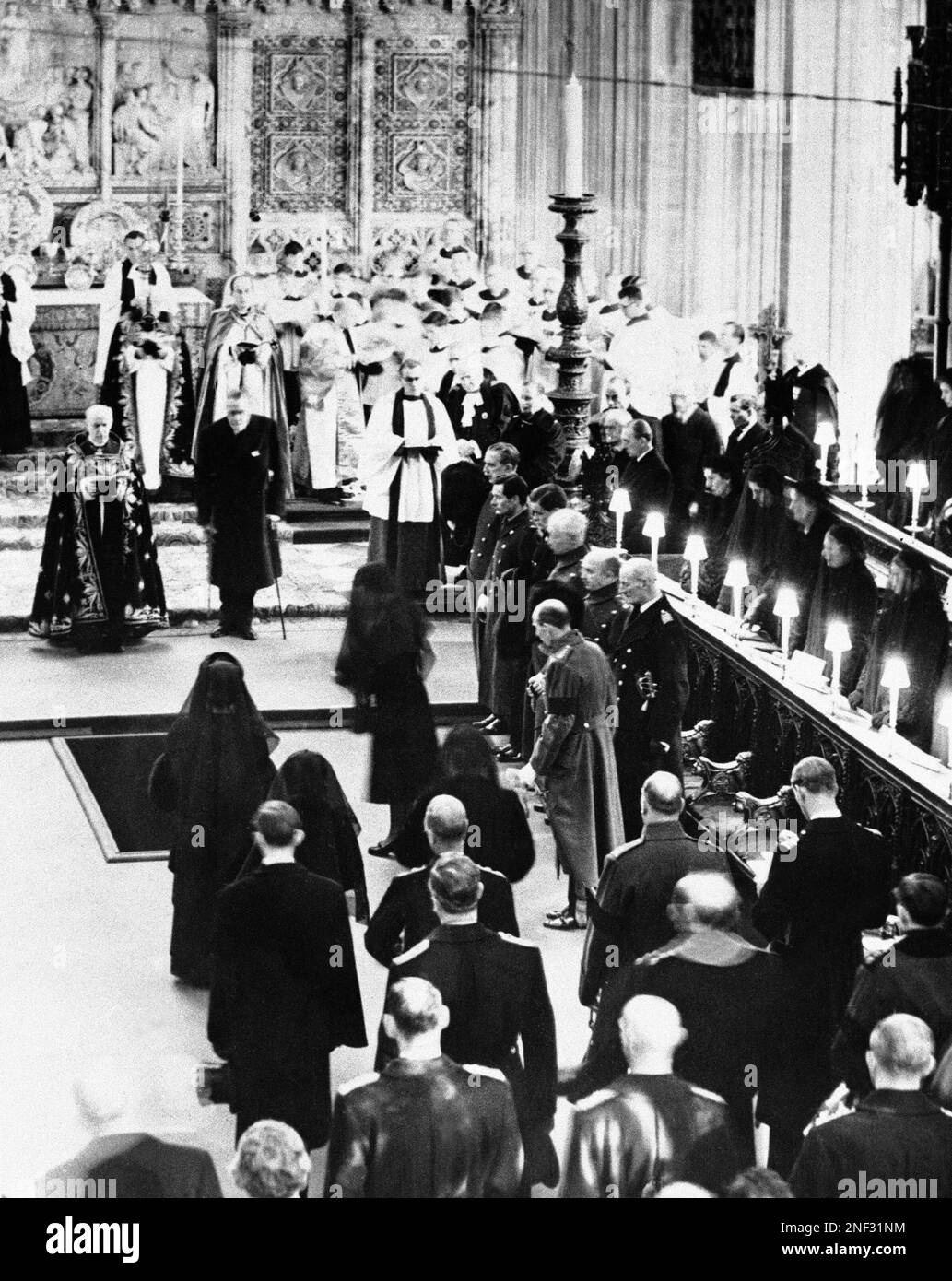 Queen Elizabeth II stands to the right of the open crypt in Windsor ...