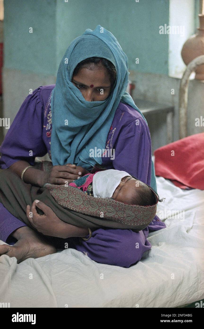 A mother cradles her sick two-year-old son in the plague ward of the ...