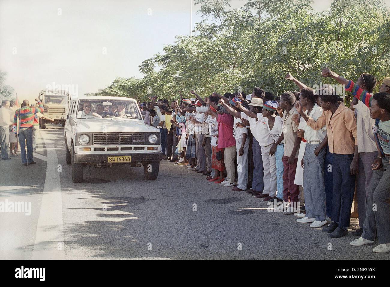 South West African People Organization (SWAPO) members line the street ...