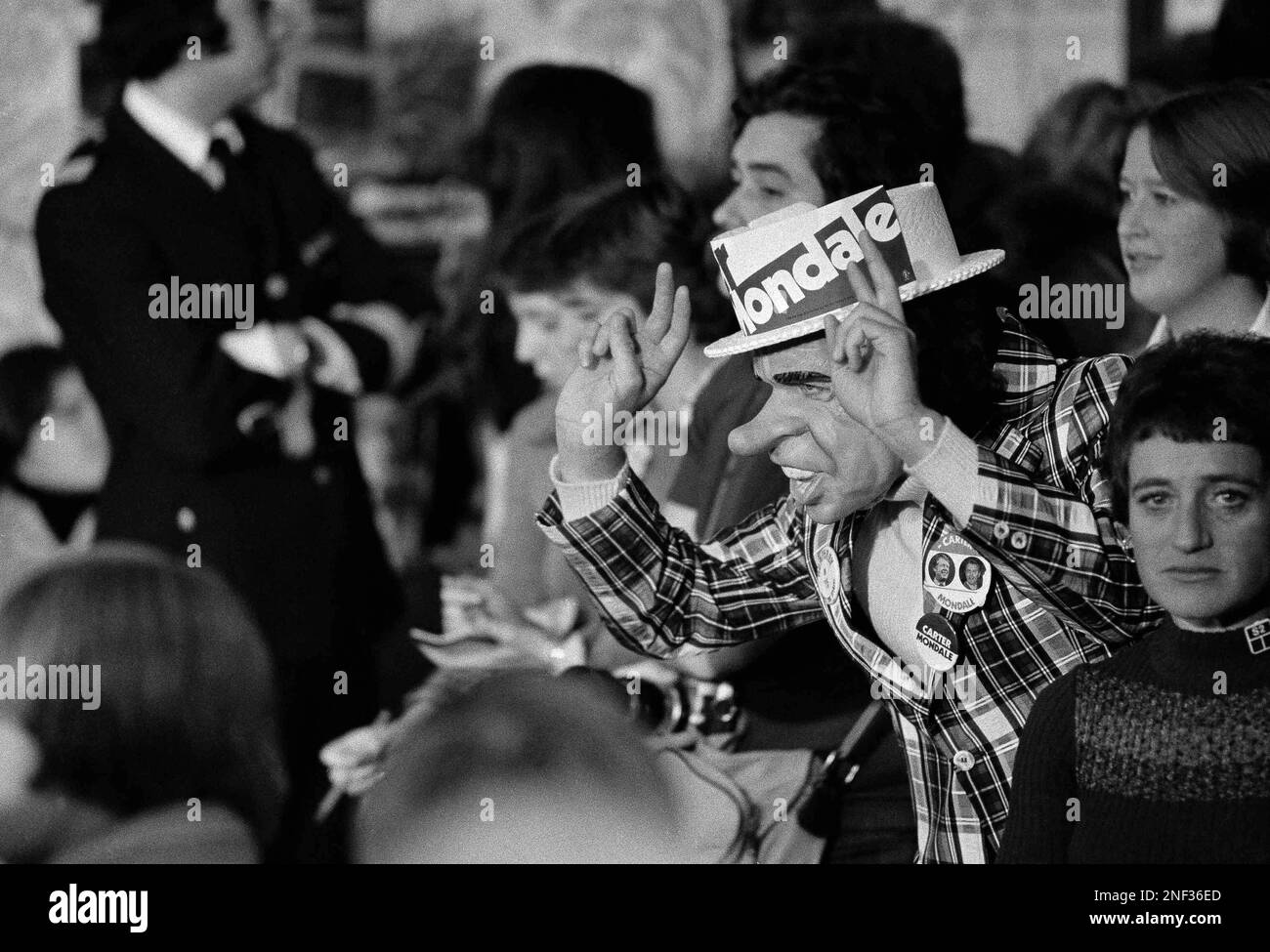 A man attending Sen. Walter Mondale's election party flashes the peace ...