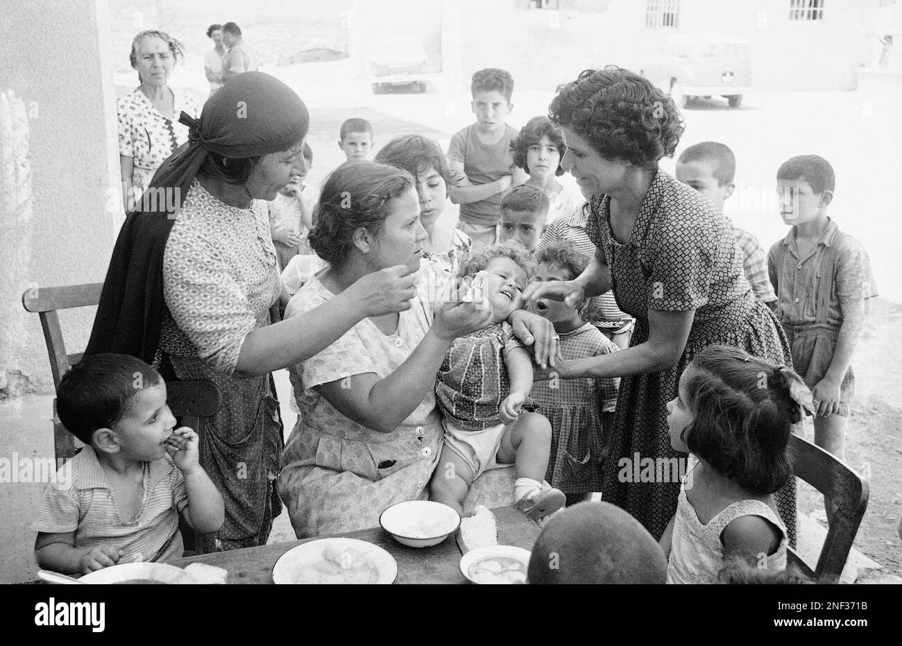 Other women try to help a mother feeding a reluctant child at a Turkish ...
