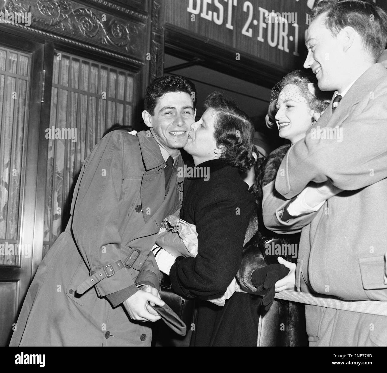 Corporal Eddie Fisher, singer home on furlough, receives a kiss from an ...