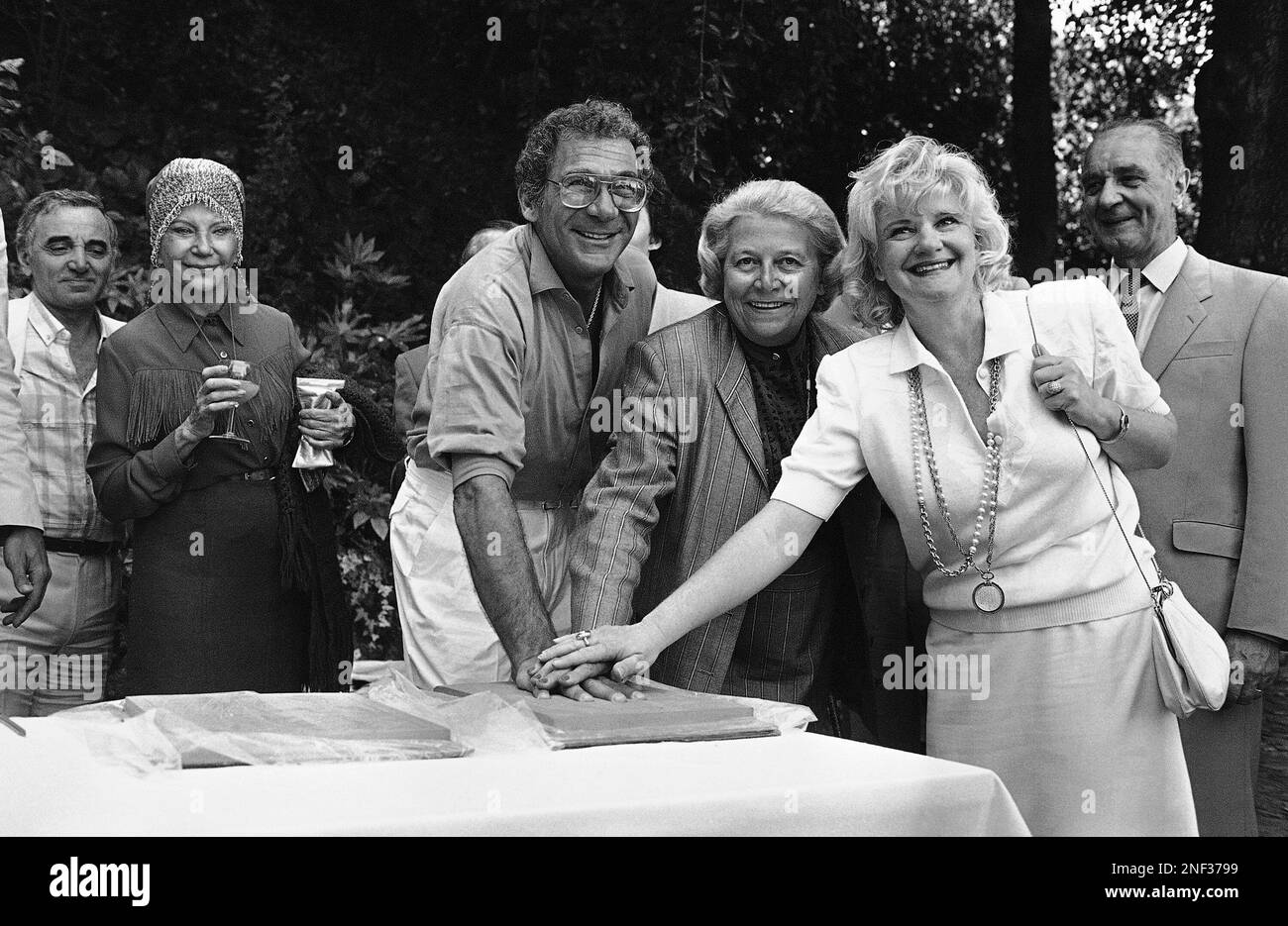 American film director Sydney Pollack, left, making a hand print in a ...