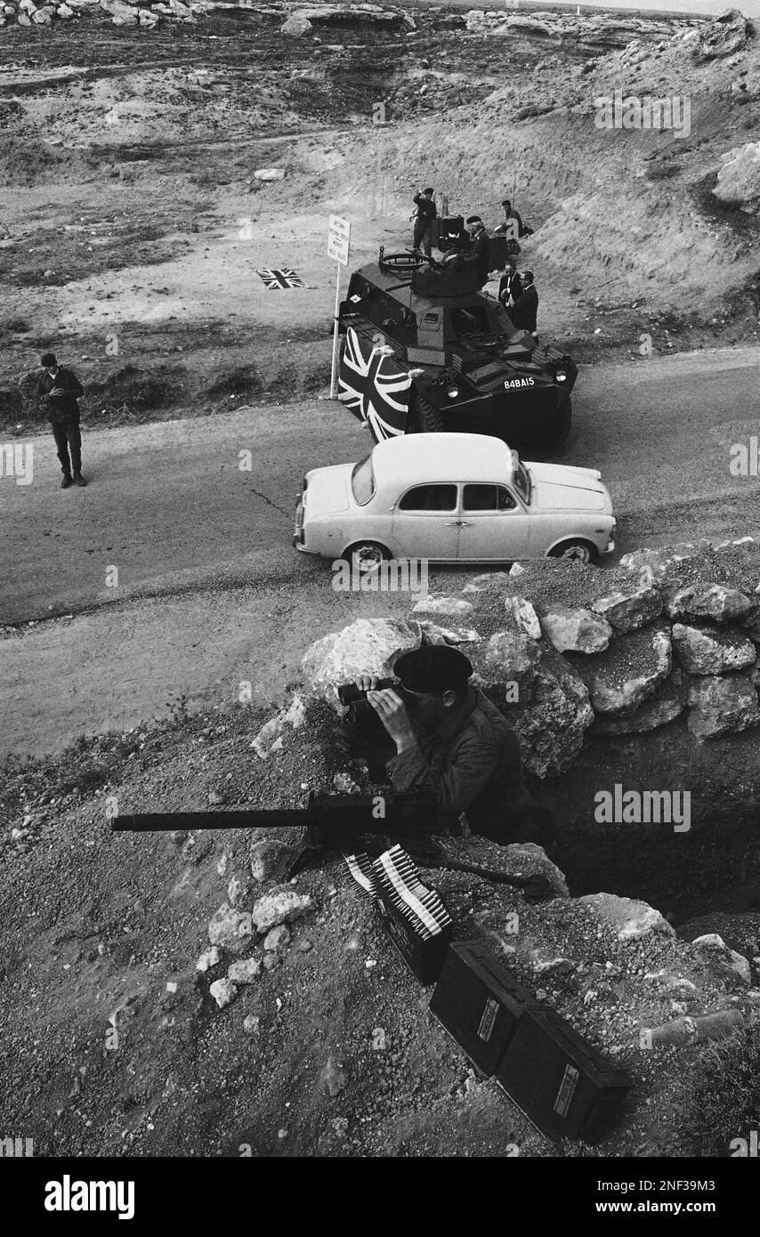 British machine gunner Philip Andrews looks through binoculars at ...