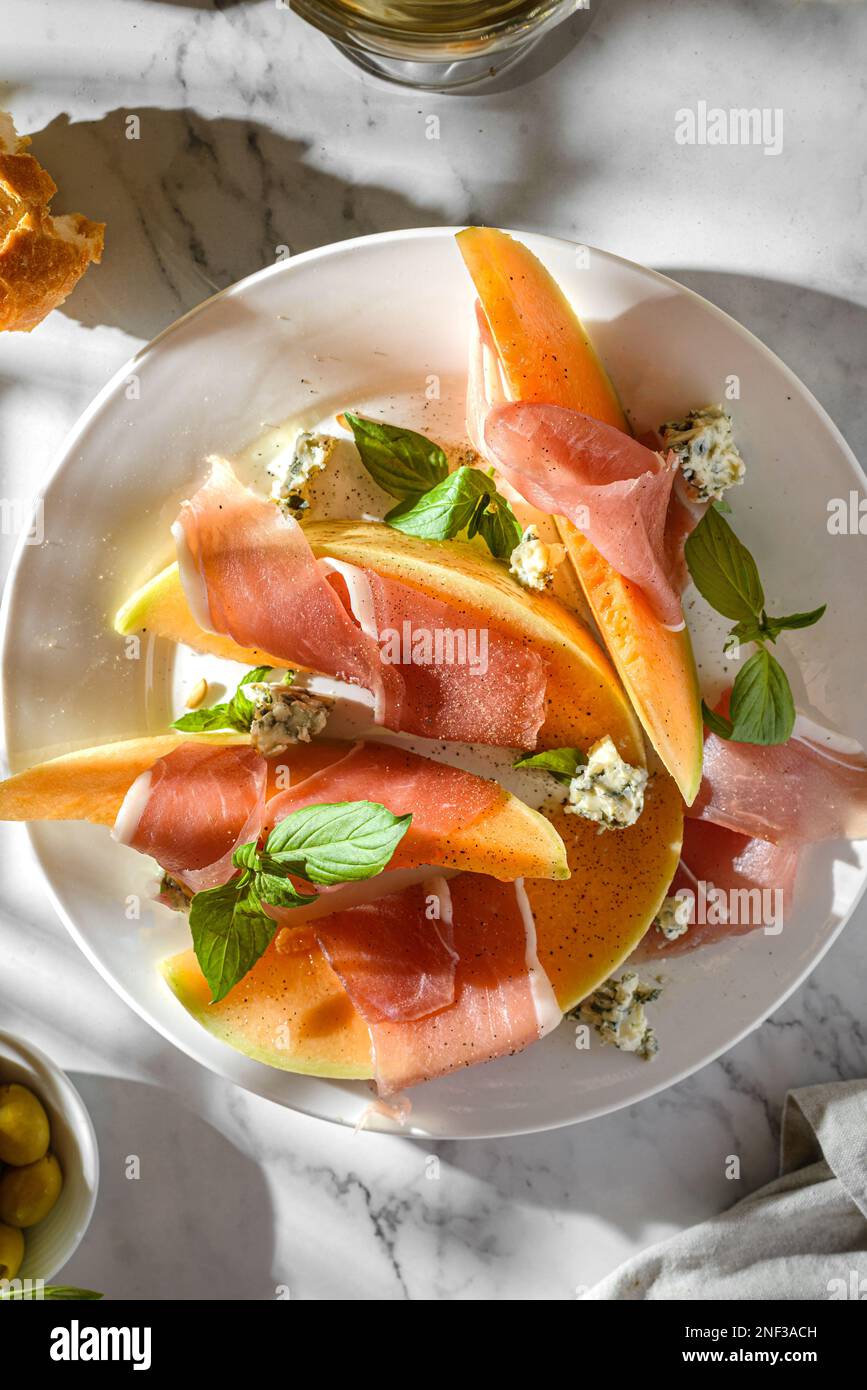 melon with parma and cheese on a marble backgroundphoto, white wine ...