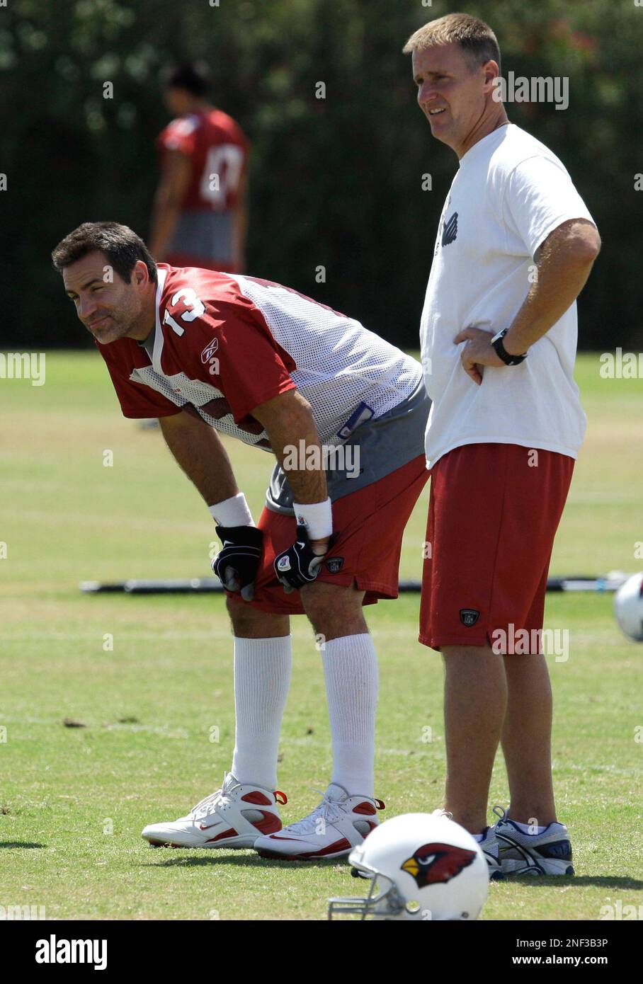 Arizona Cardinals' Kurt Warner, left, chats with a trainer during the ...