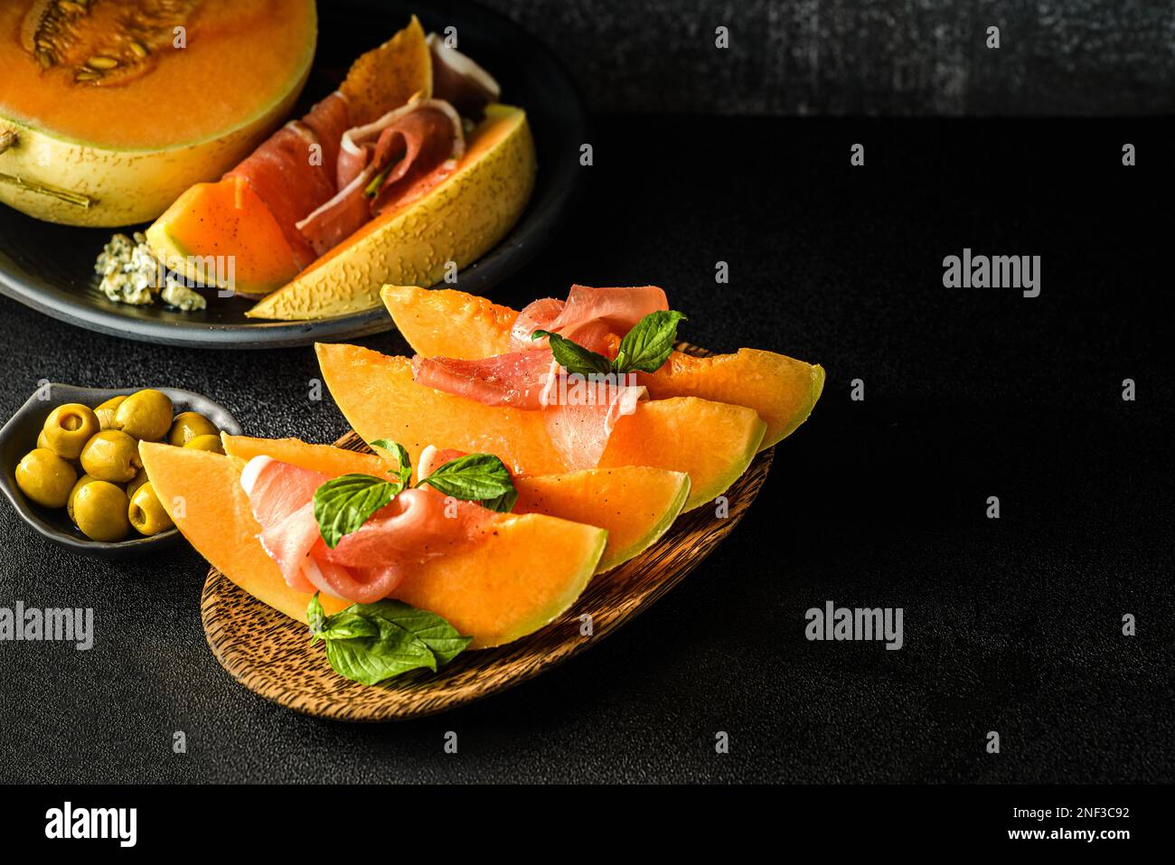 melon with parma, olives and baguette. snacks for wine and a glass of ...