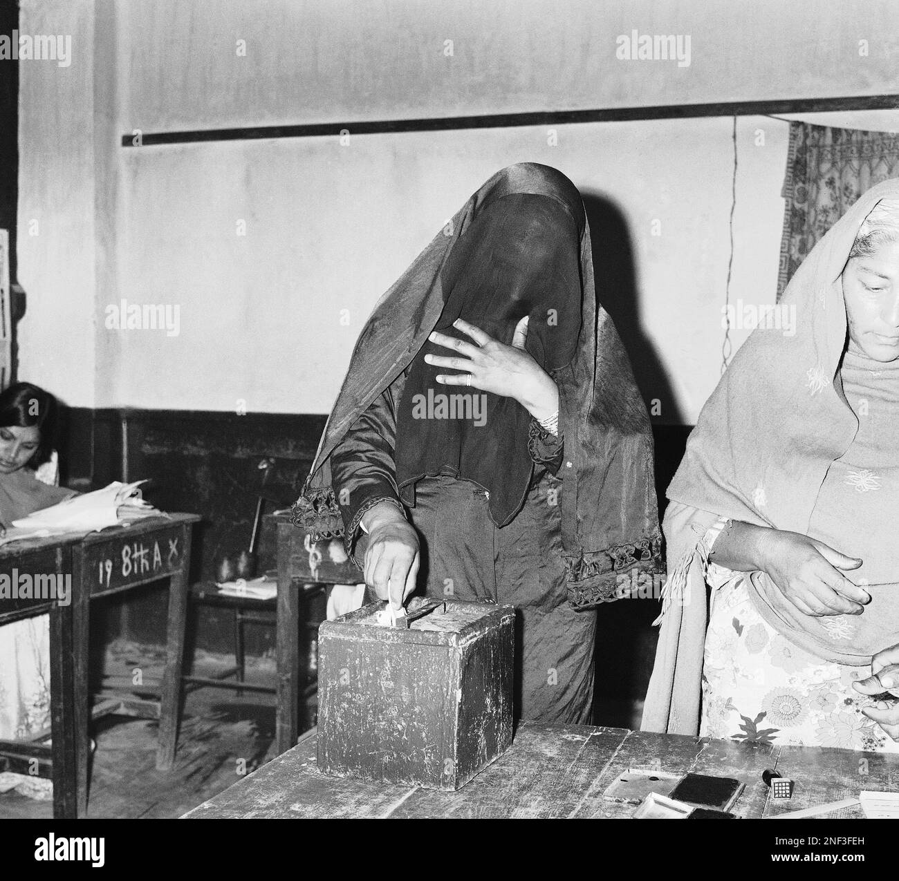 A veiled Pakistani woman casts her vote in a polling station in ...