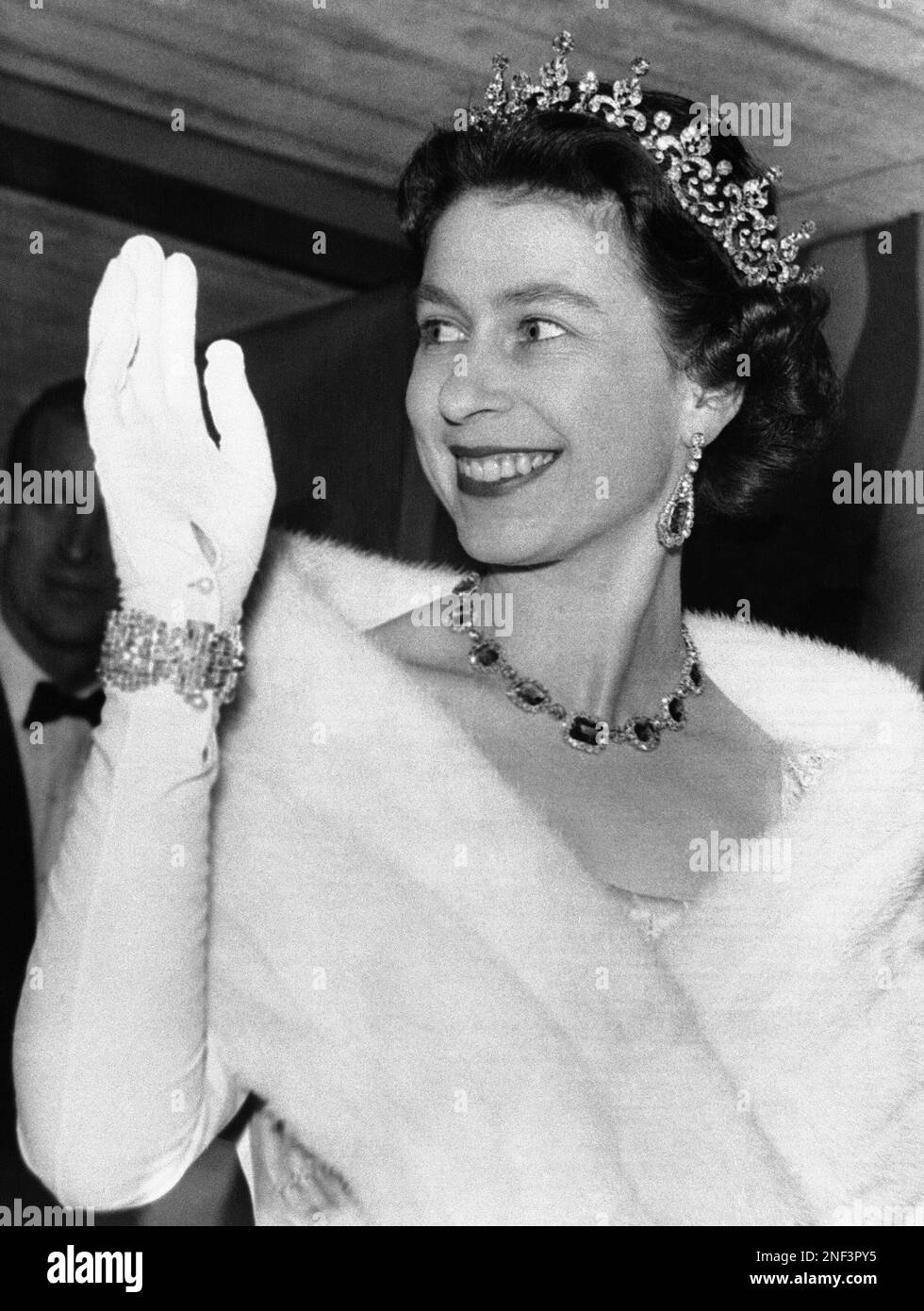 Queen Elizabeth II in white satin evening gown, white fur wrap and ...