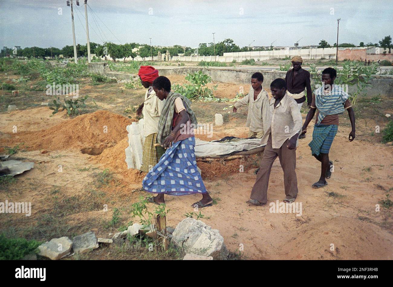 Relatives carry the shrouded corpse of an elderly man after his death ...