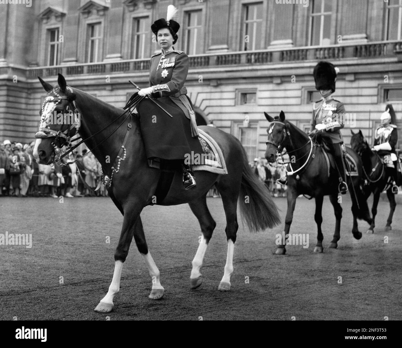Queen Elizabeth II, wearing the scarlet tunic, blue riding habit and ...
