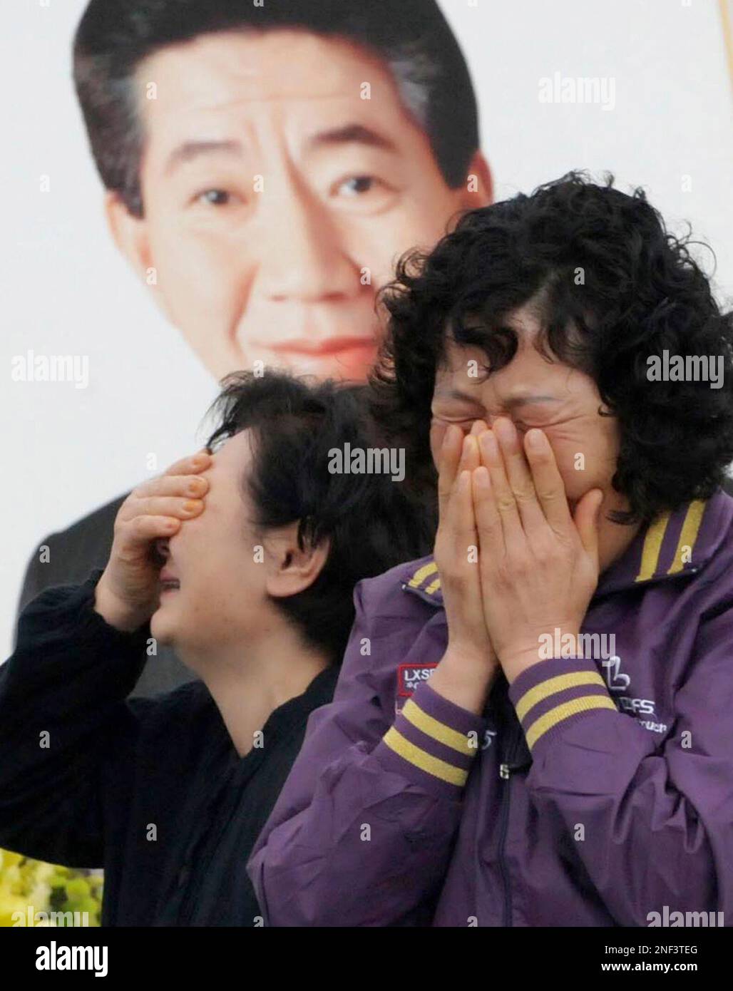South Korean women cry in front of a portrait of former President Roh ...