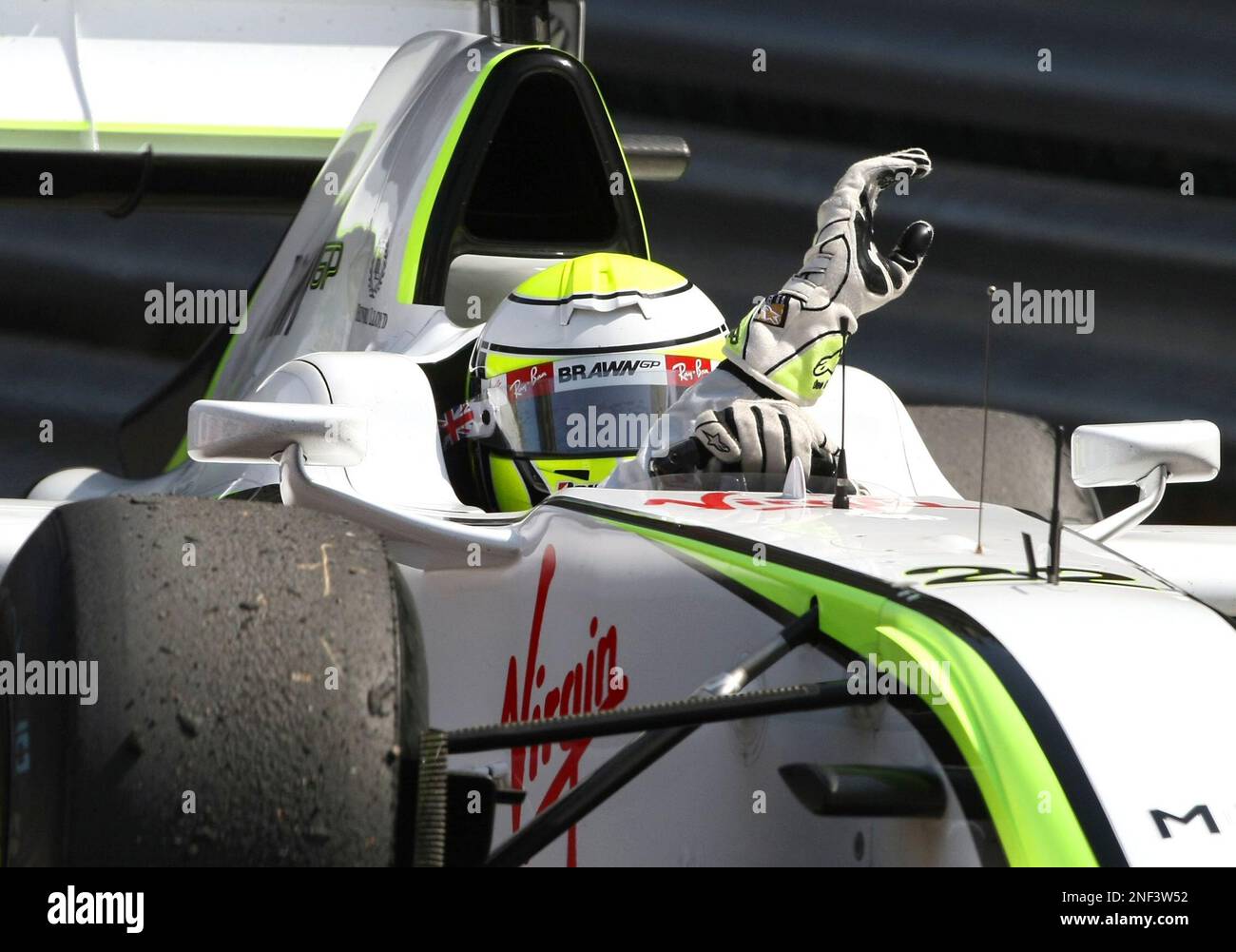 Brawn GP driver Jenson Button of Britain waves from the cockpit after ...