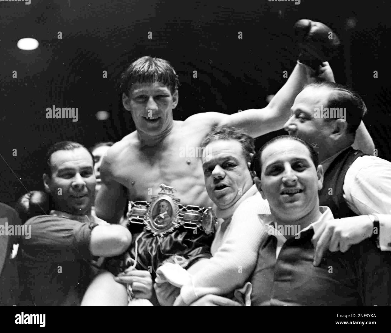 Britain's Eric Boon, wearing the Lonsdale Belt, is hoisted up by his seconds after knocking out ...