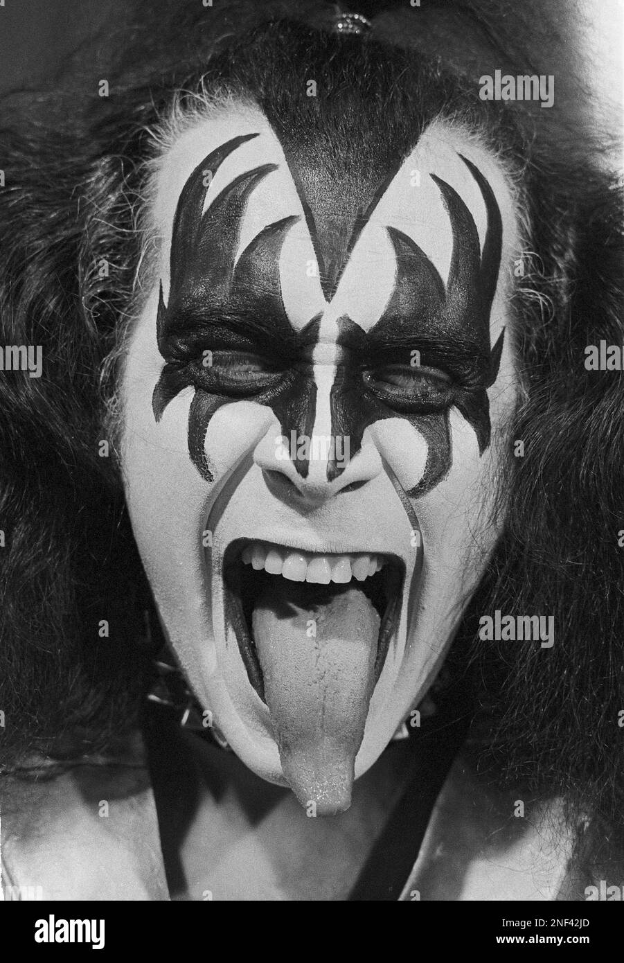 Gene Simmons, the vampire figure of the rock group KISS extends his ...