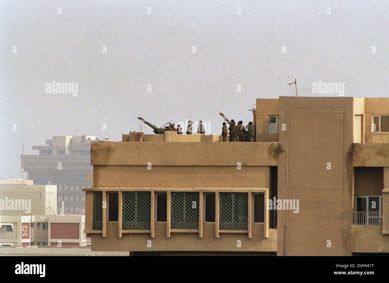 Iraqi soldiers stand ready at their anti aircraft guns following an air ...