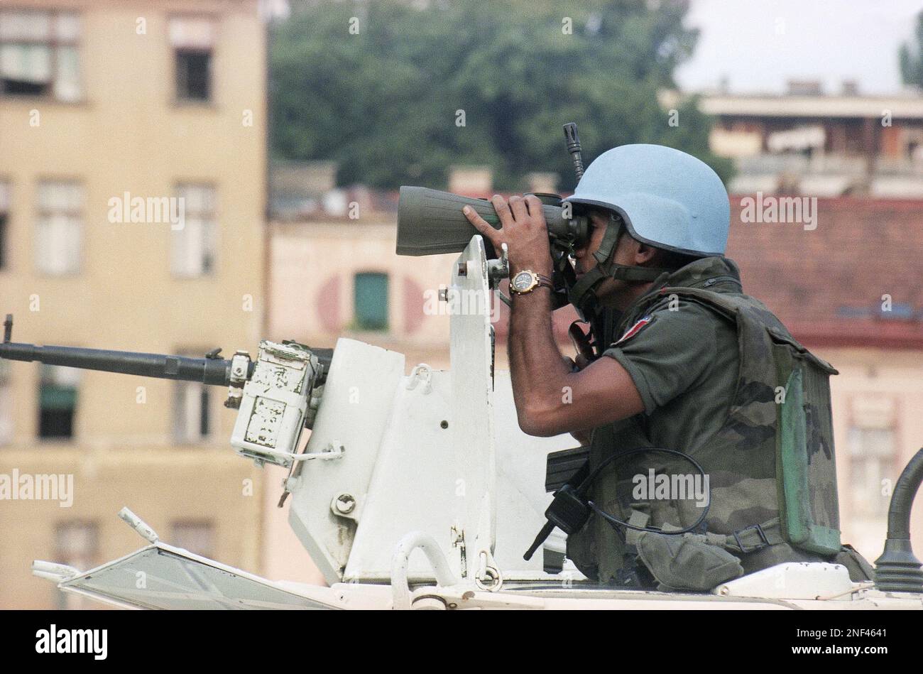 A French peacekeeper peers through binoculars on Friday, August 5, 1994 ...