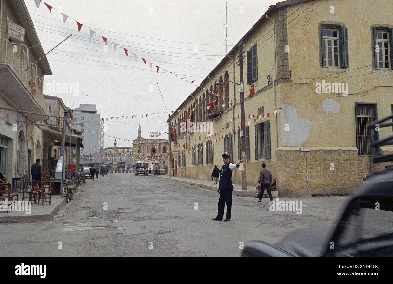 A Turkish police station covered with flags and a traffic cop giving ...