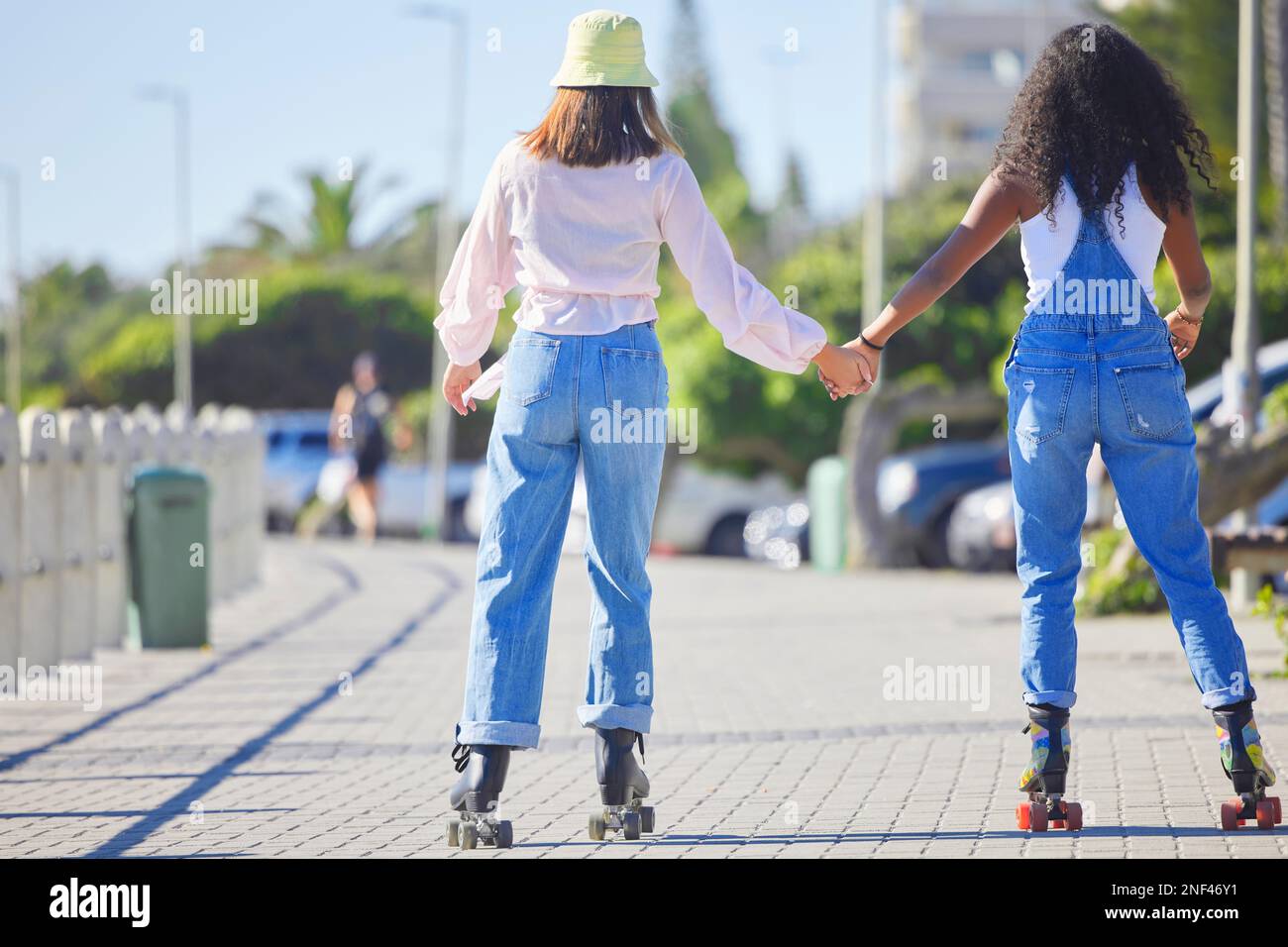 Rollerblading, holding hands and girl friends back on outdoor promenade ...
