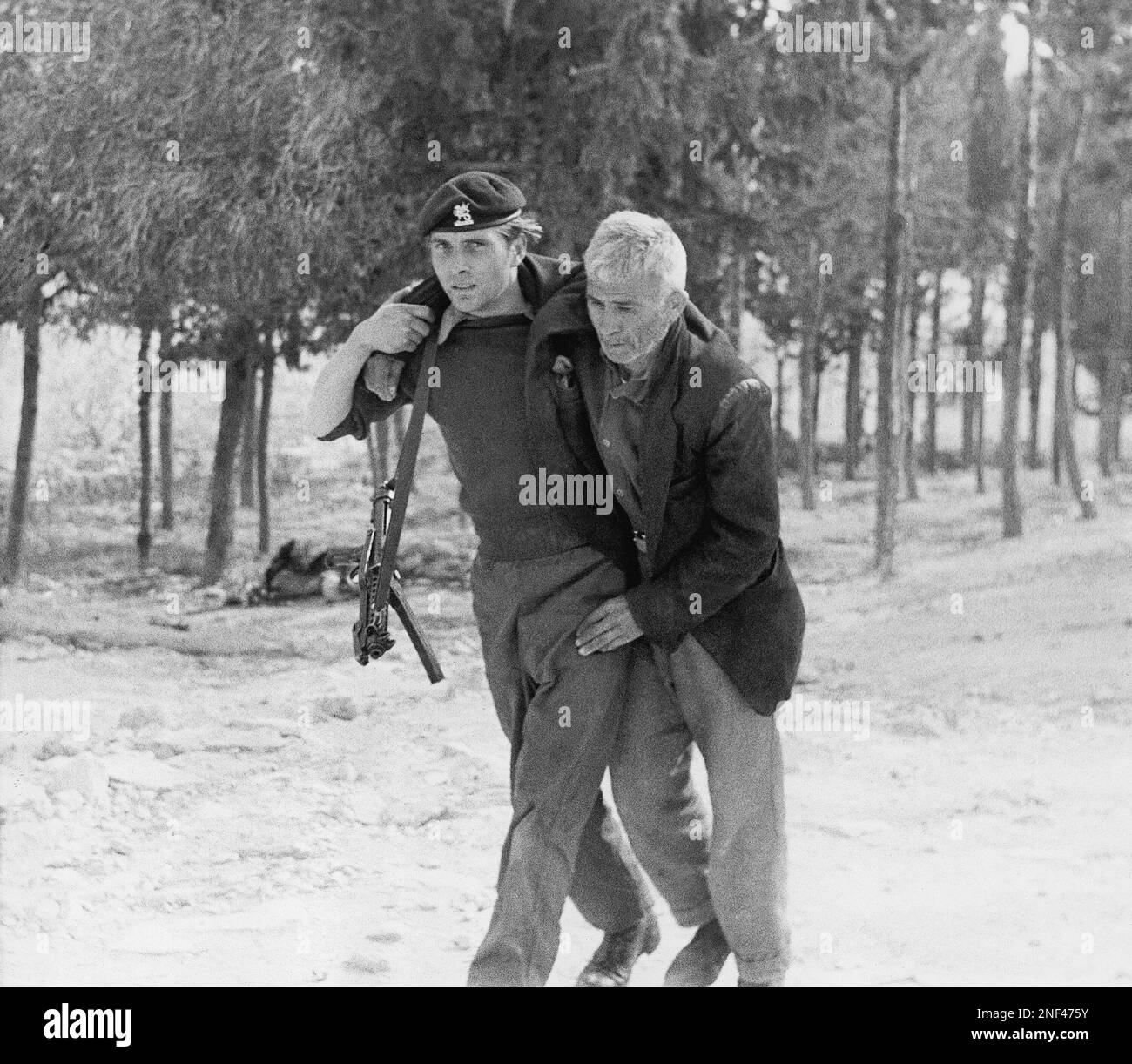 A British soldier helps a Turkish Cypriot to safety during fighting ...
