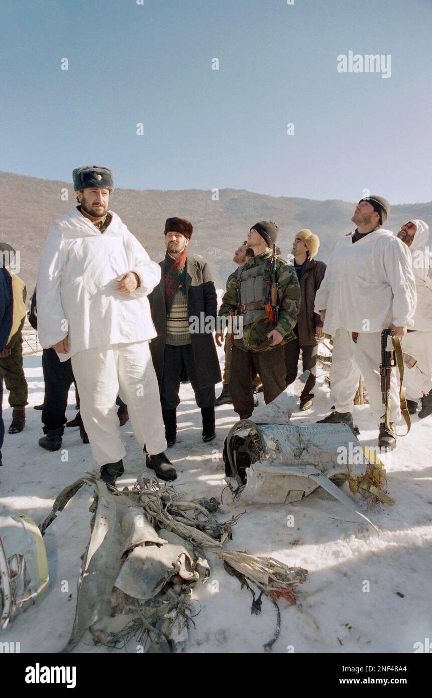 Chechen volunteers stand beside the remains of a rocket fired by a ...