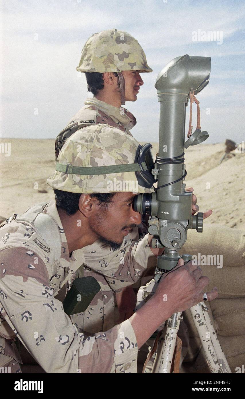 A Saudi army officer, using high power binoculars, scans the horizon ...