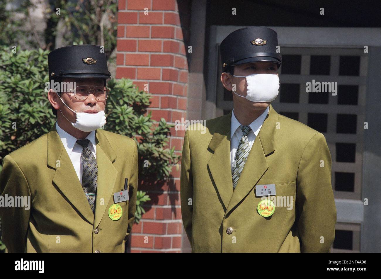 Wearing a cloth mask, subway employees stand outside Kasumigaseki ...