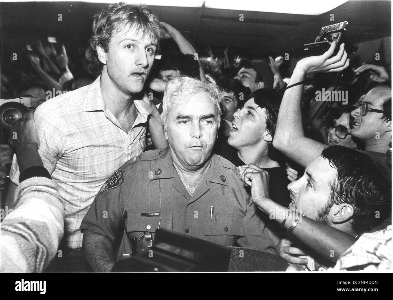 A wave of fans crowd Boston Celtics star Larry Bird as he and his ...