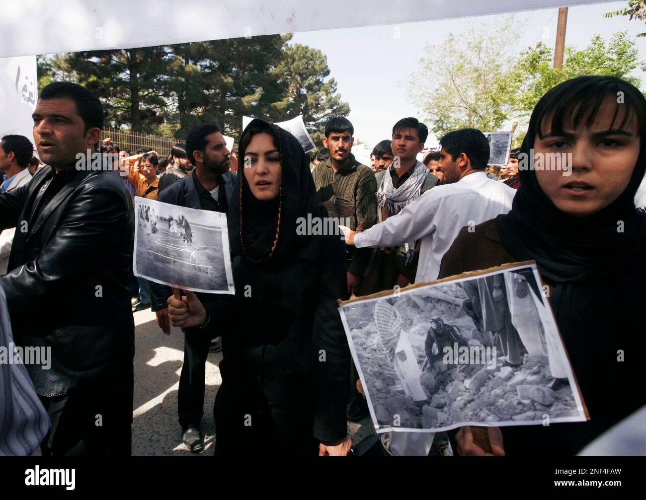 Afghan students of Kabul University hold photos of the aftermath of ...