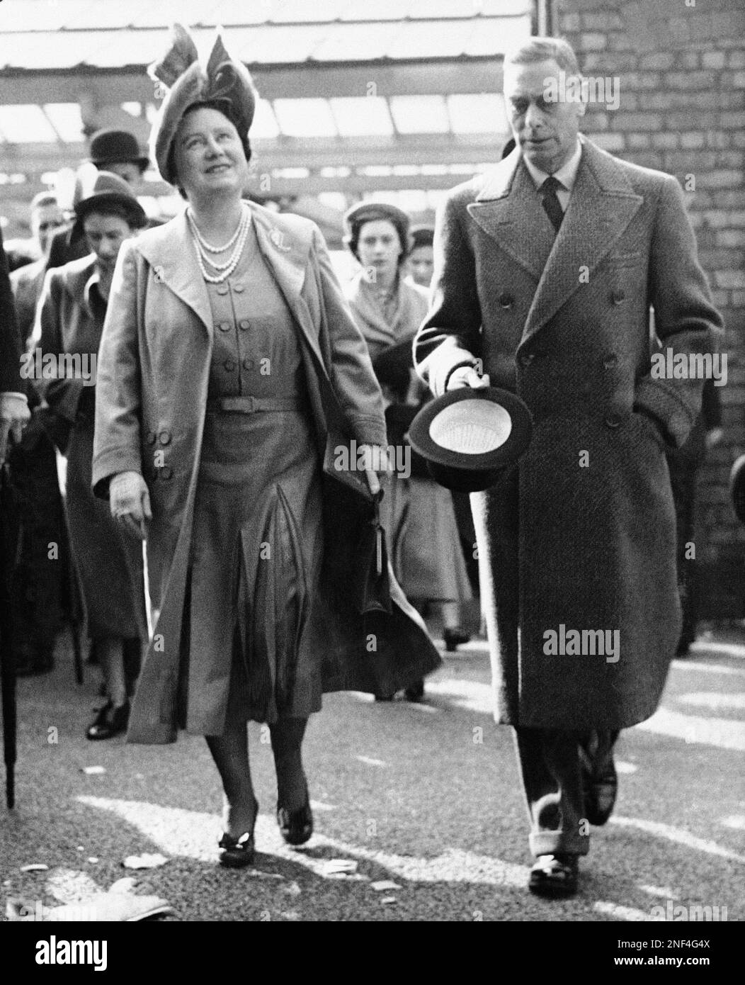 King George VI and Queen Elizabeth walk in the paddock on their way to ...