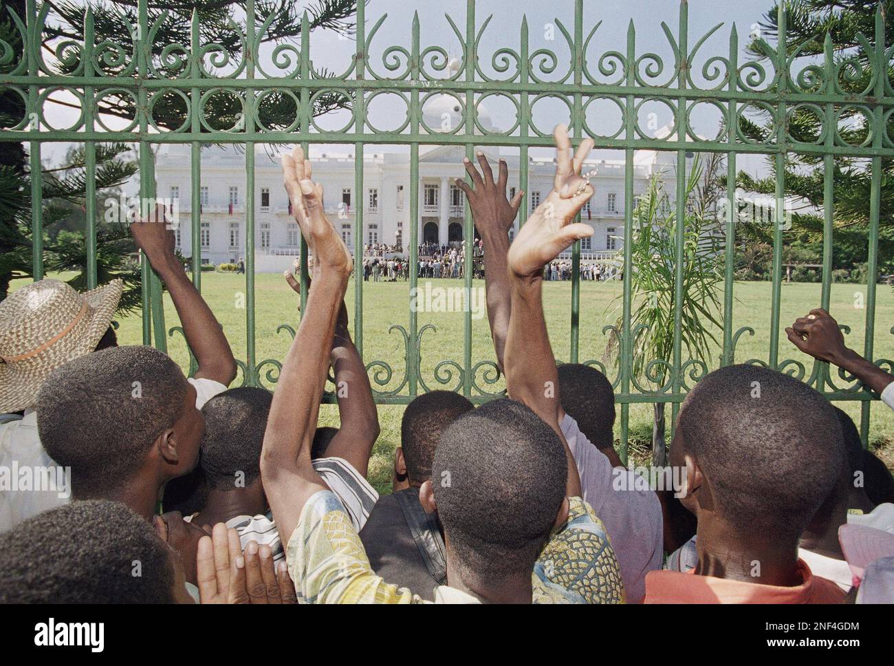 Haitians crowd the iron fence around the National Palace in Port-au ...