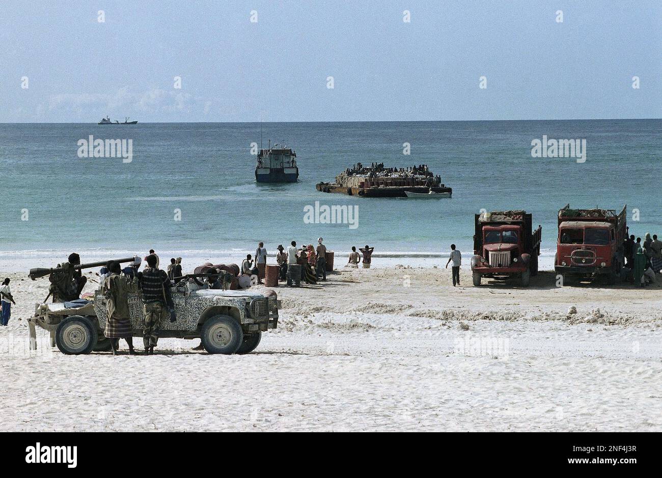 Armed guards look on as a barge chartered by the International ...