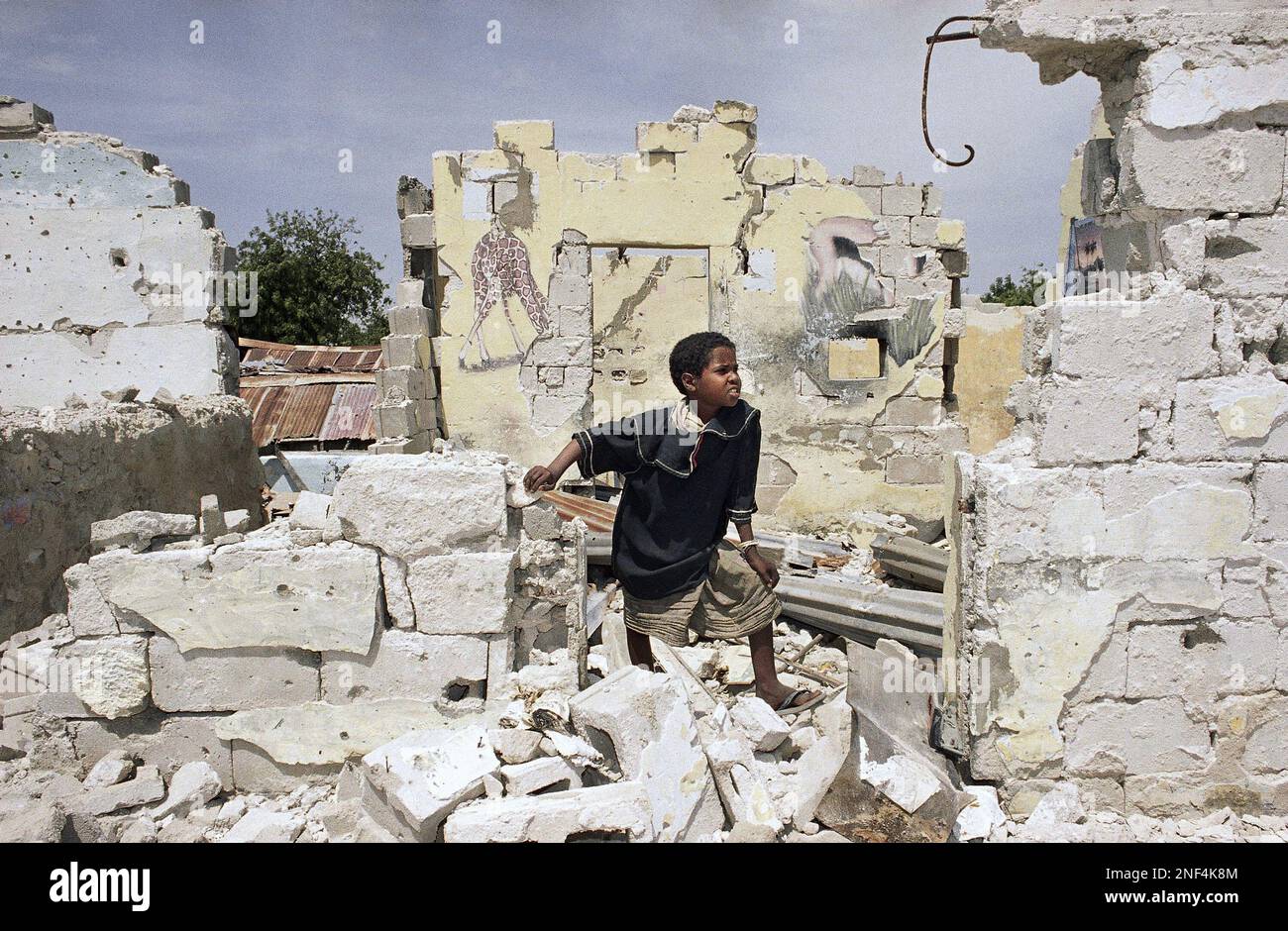 A young Somali boy watches from ruins as representatives of rival ...