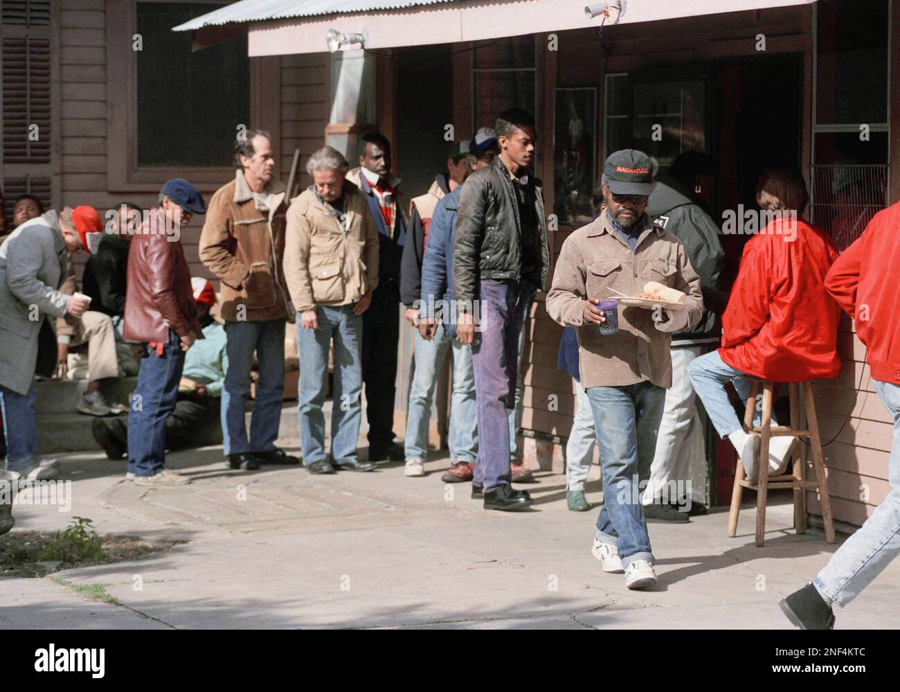 Men line up to receive their free lunch at the Center of Jesus the Lord ...