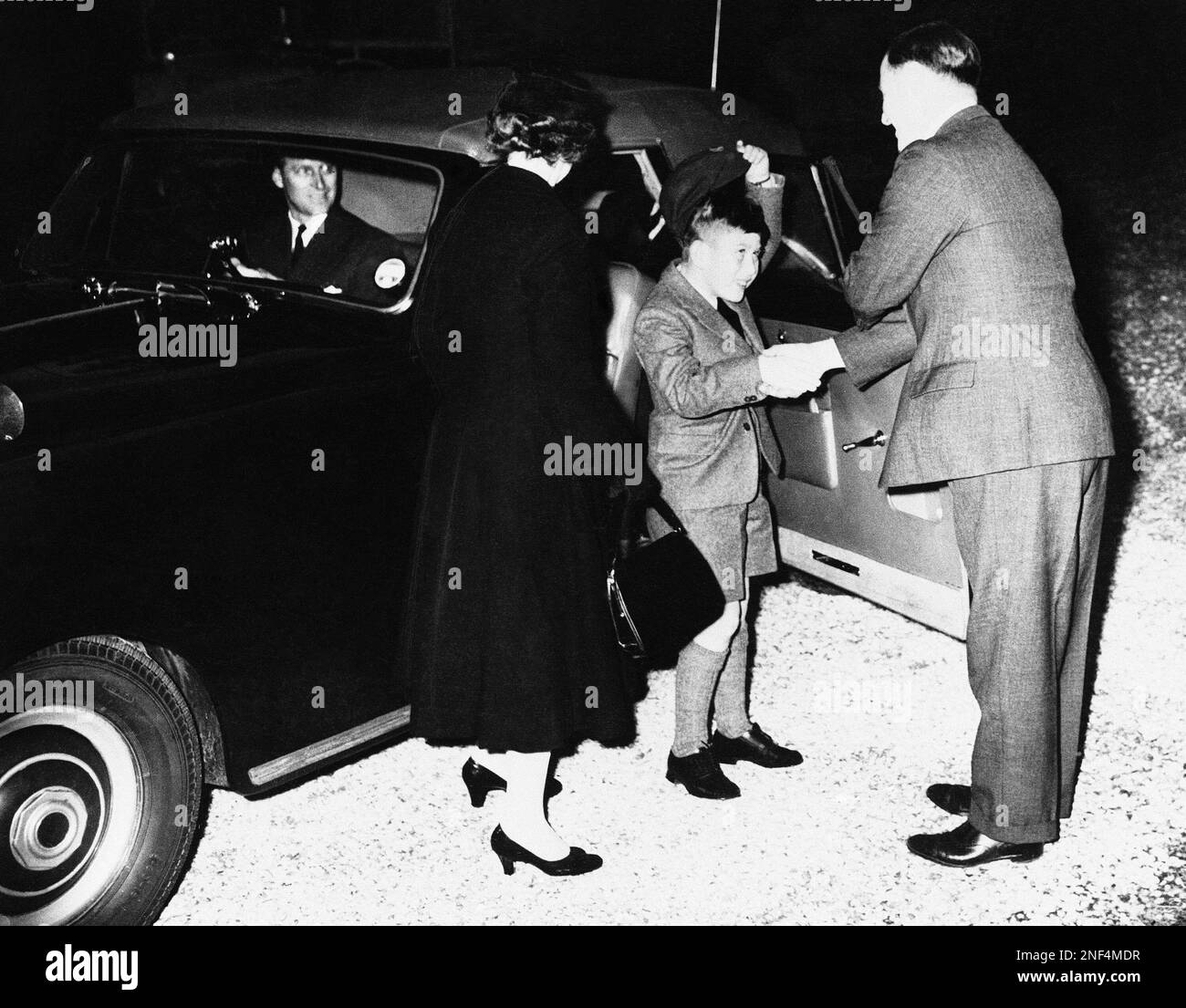 Prince Charles of England raises his cap and smiles on receiving a ...